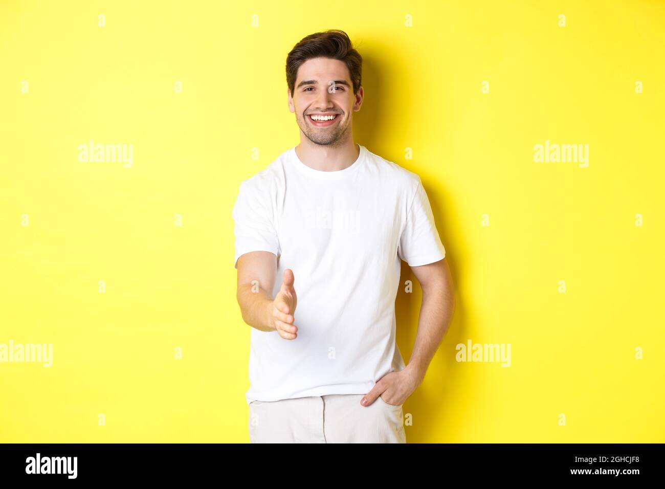 Handsome and confident man extending hand for handshake, greeting you ...
