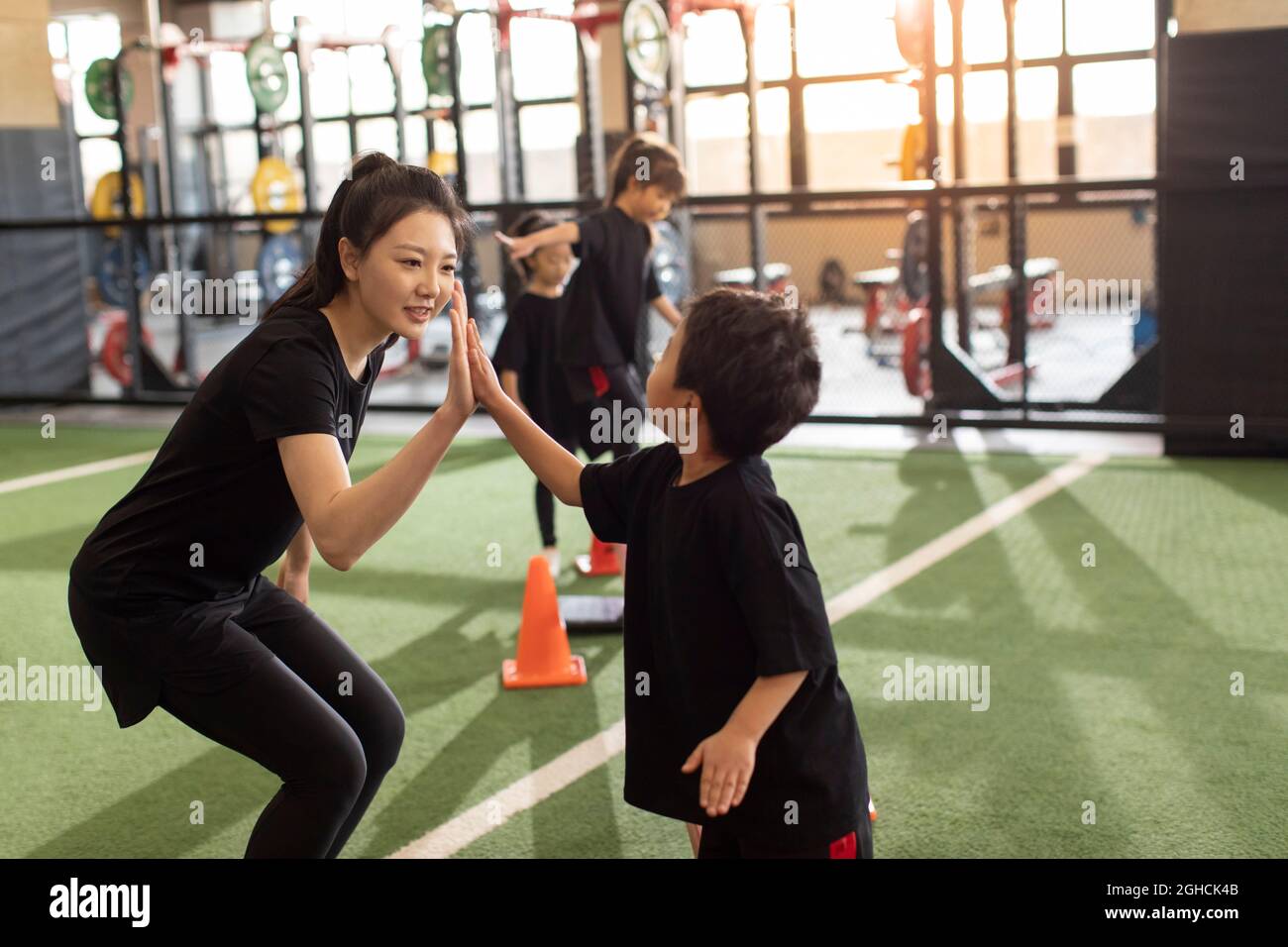 Active children having exercise class with their coach in gym Stock ...