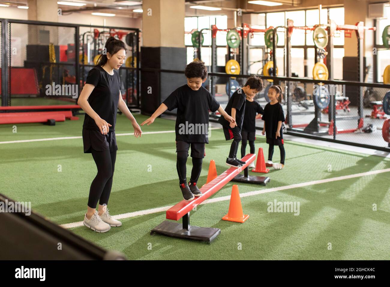 Active children having exercise class with their coach in gym Stock ...