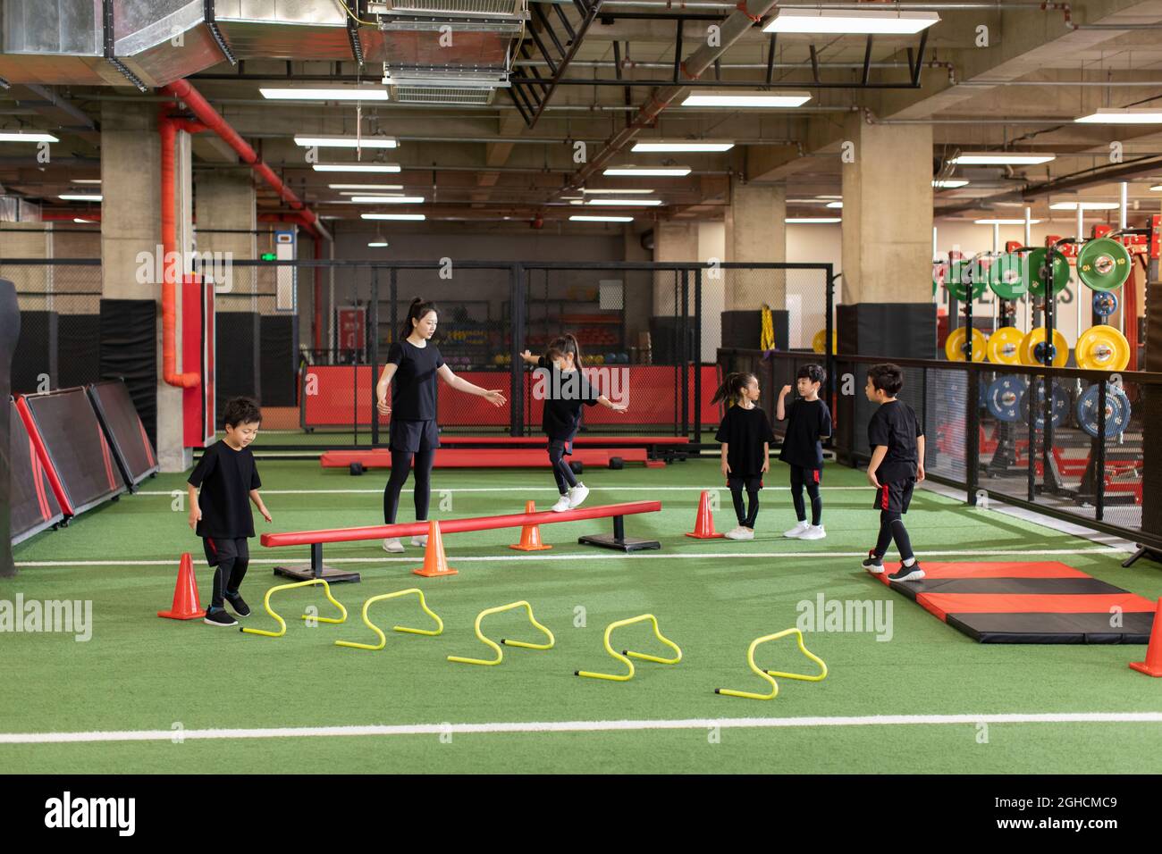 Active children having exercise class with their coach in gym Stock ...