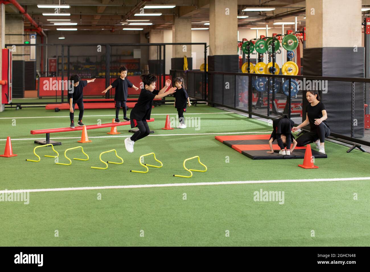 Active children having exercise class with their coach in gym Stock ...