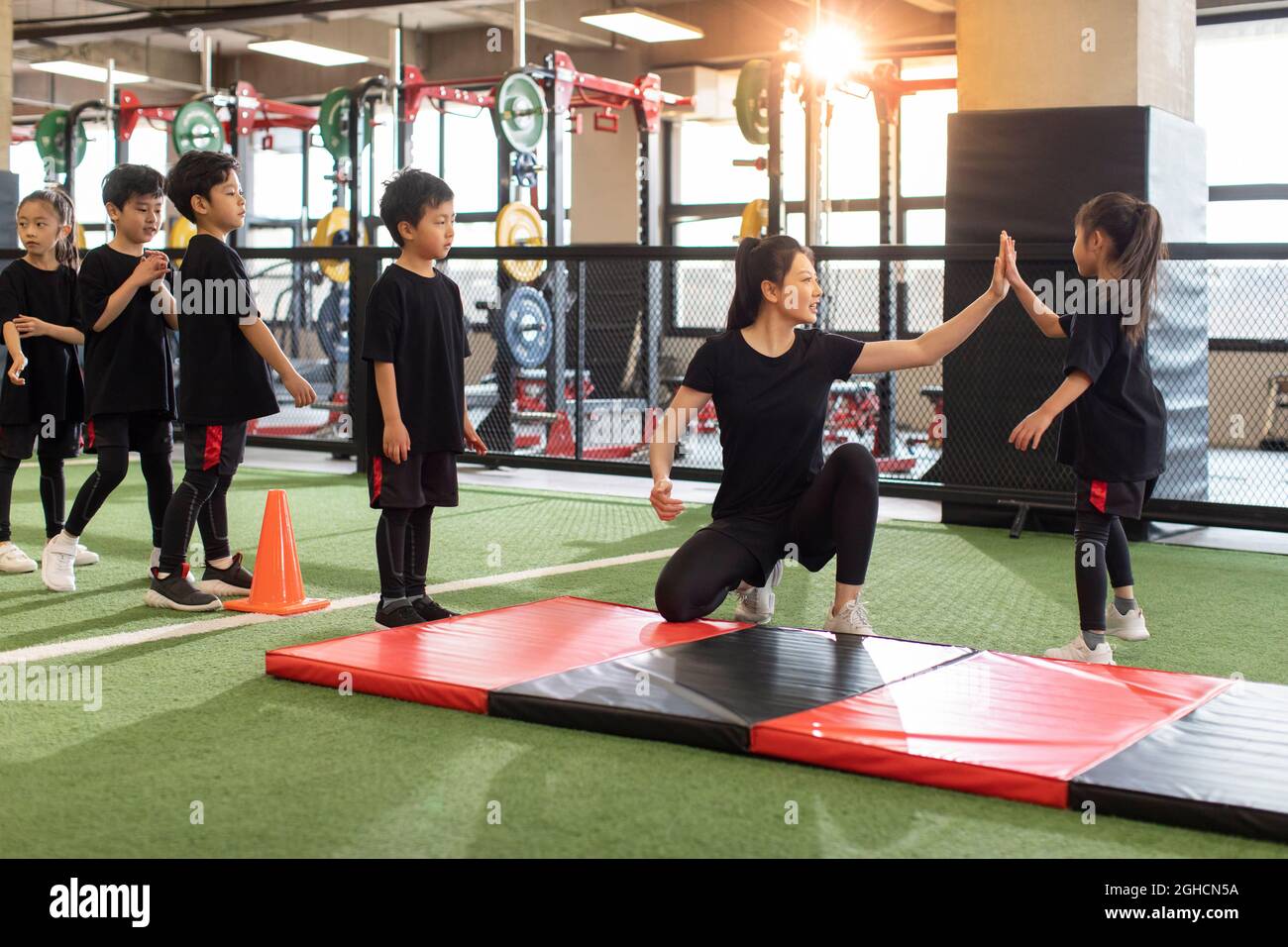 Active children having exercise class with their coach in gym Stock ...