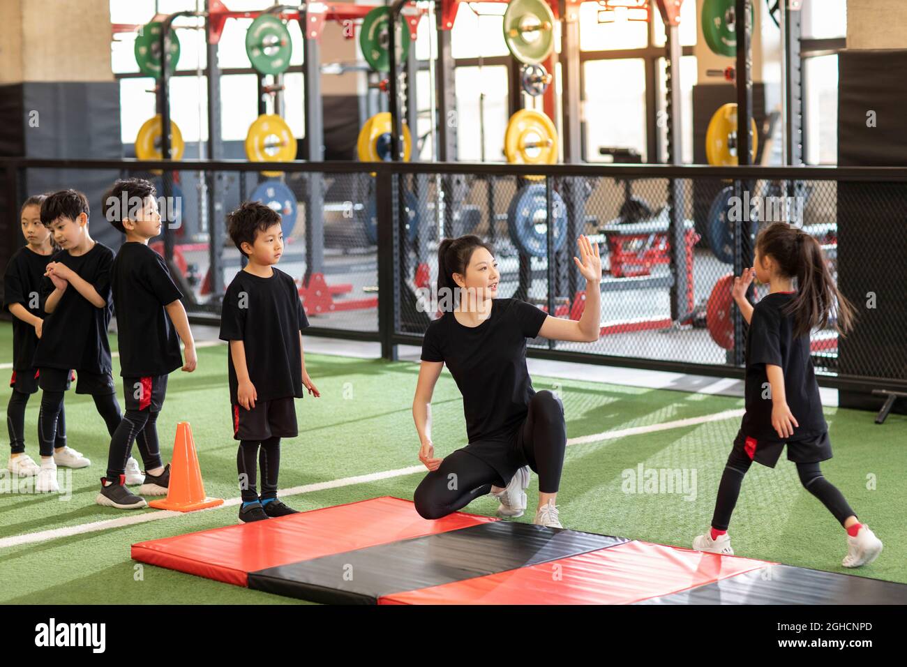 Active children having exercise class with their coach in gym Stock ...