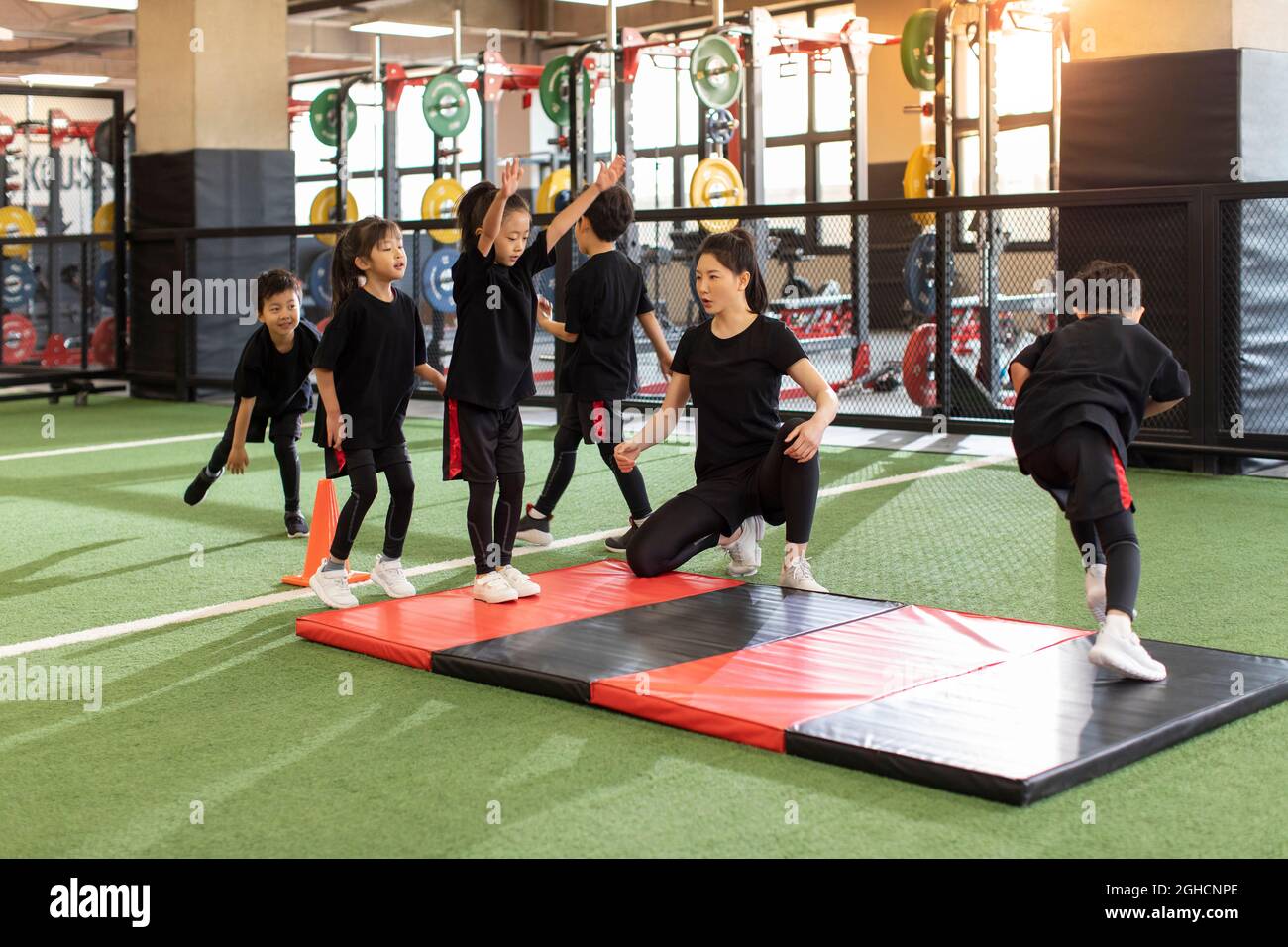 Active children having exercise class with their coach in gym Stock ...