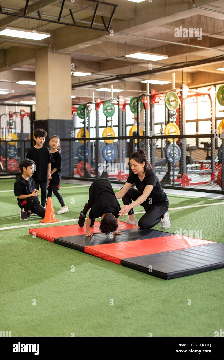 Active children having exercise class with their coach in gym Stock ...