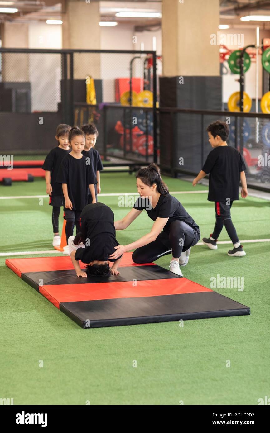 Active children having exercise class with their coach in gym Stock ...