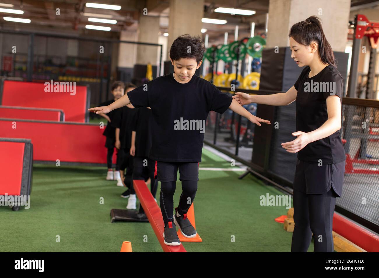 Active children having exercise class with their coach in gym Stock ...