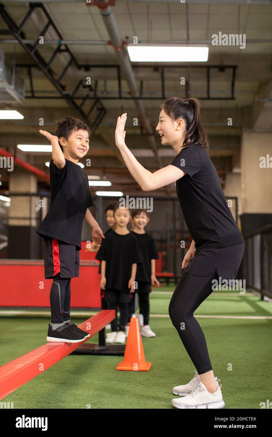 Active children having exercise class with their coach in gym Stock ...