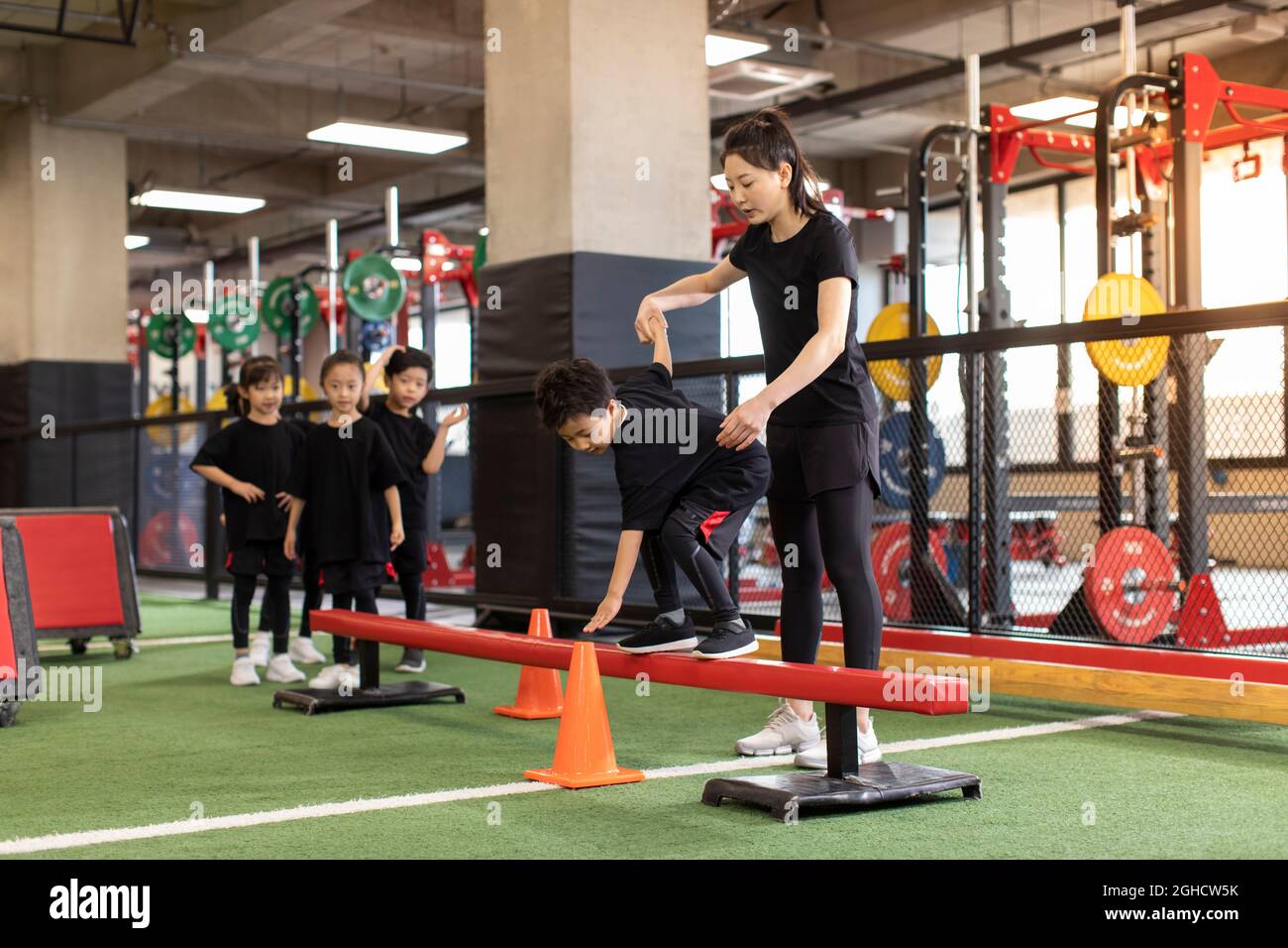 Active children having exercise class with their coach in gym Stock ...