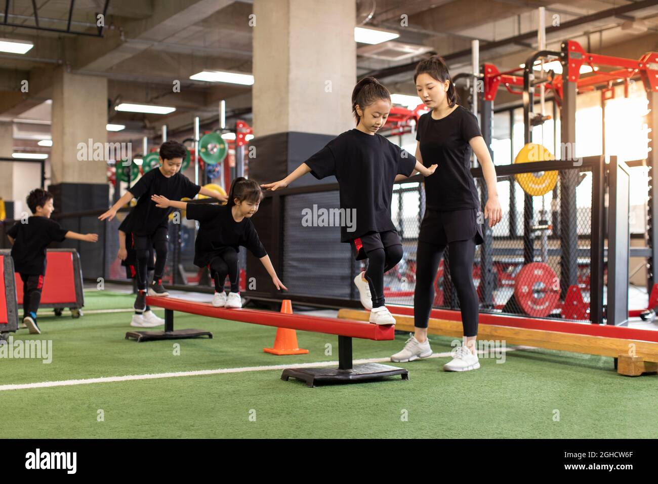 Active children having exercise class with their coach in gym Stock ...