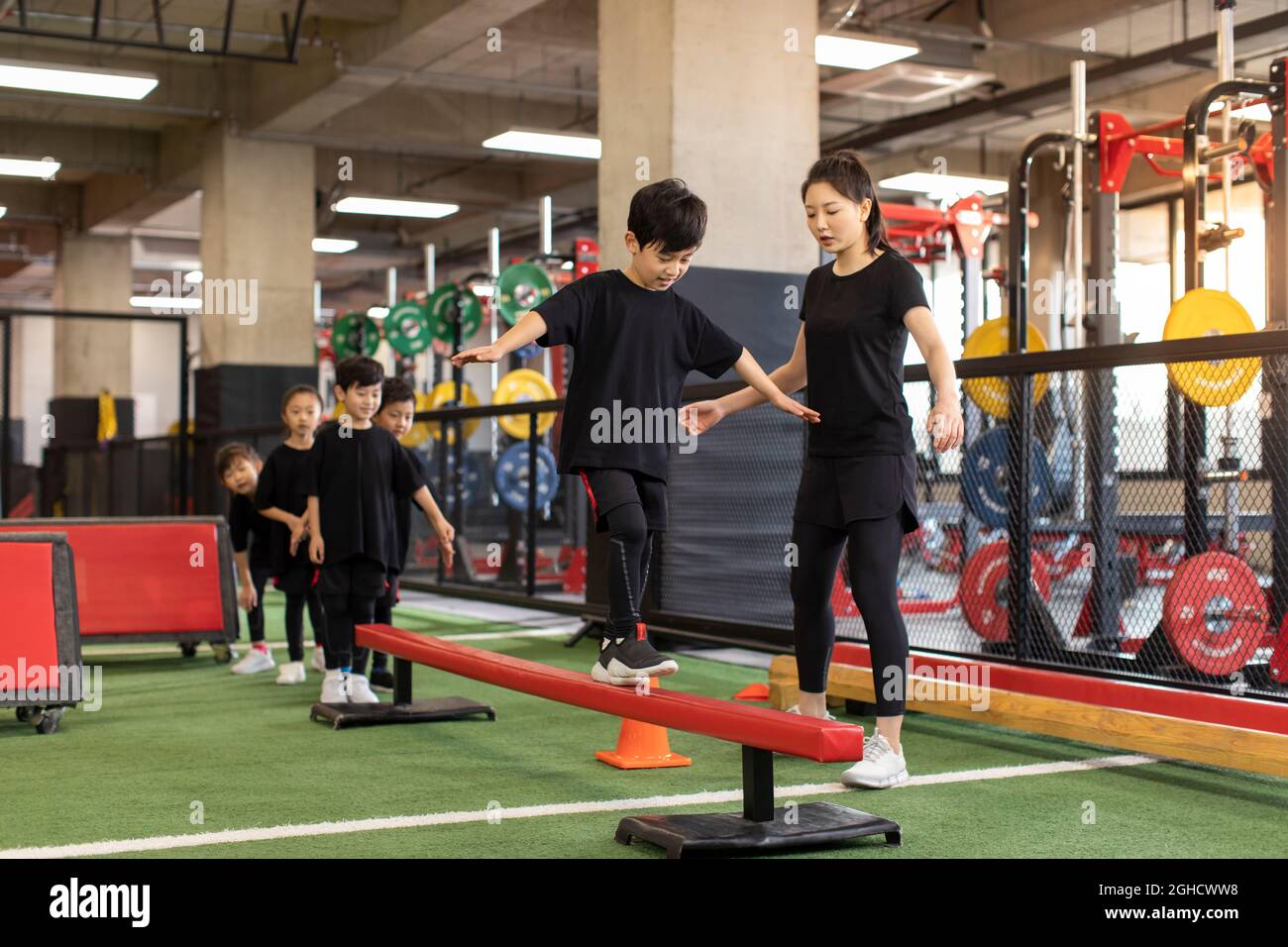 Active children having exercise class with their coach in gym Stock ...