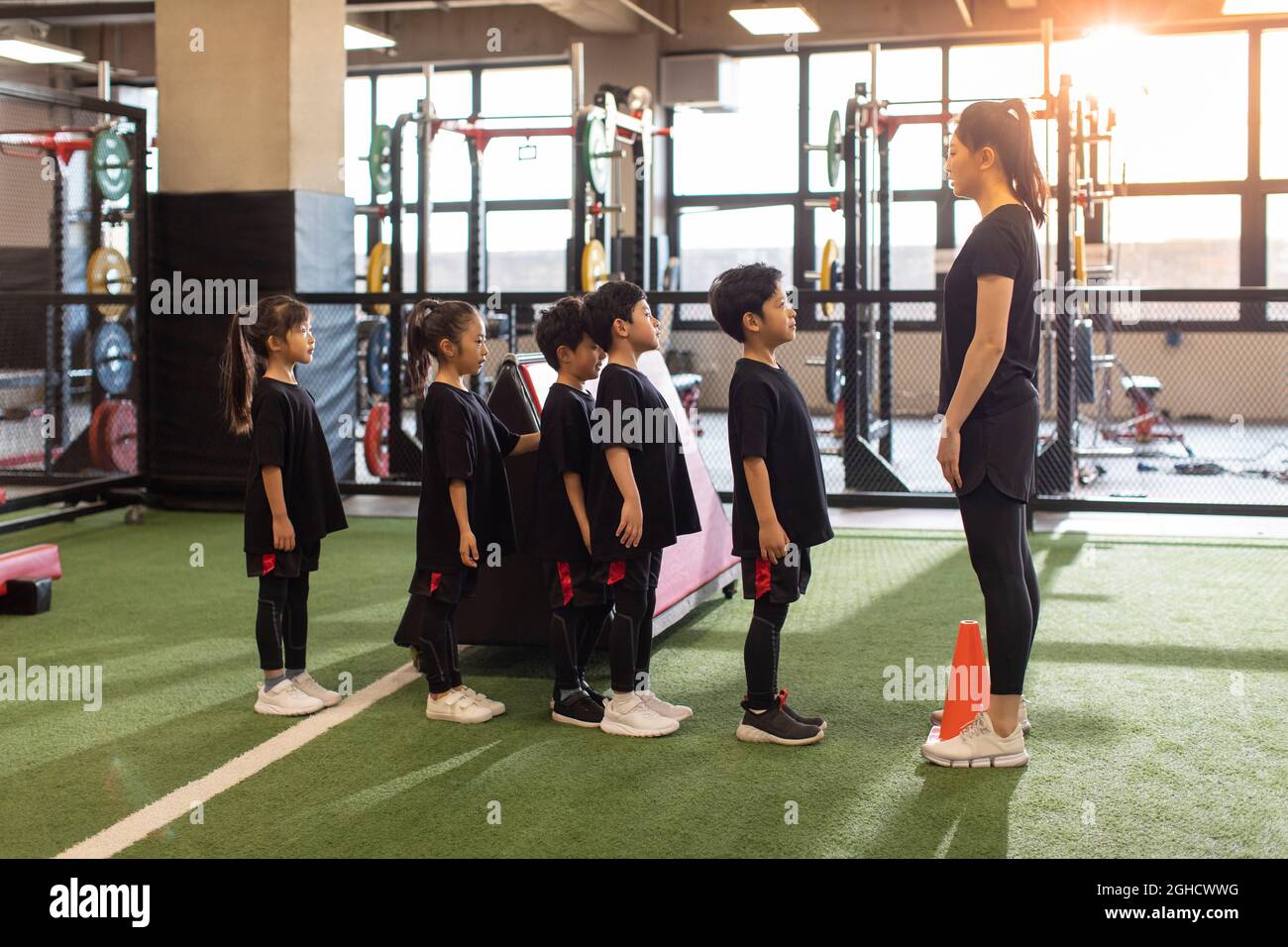 Active children having exercise class with their coach in gym Stock ...