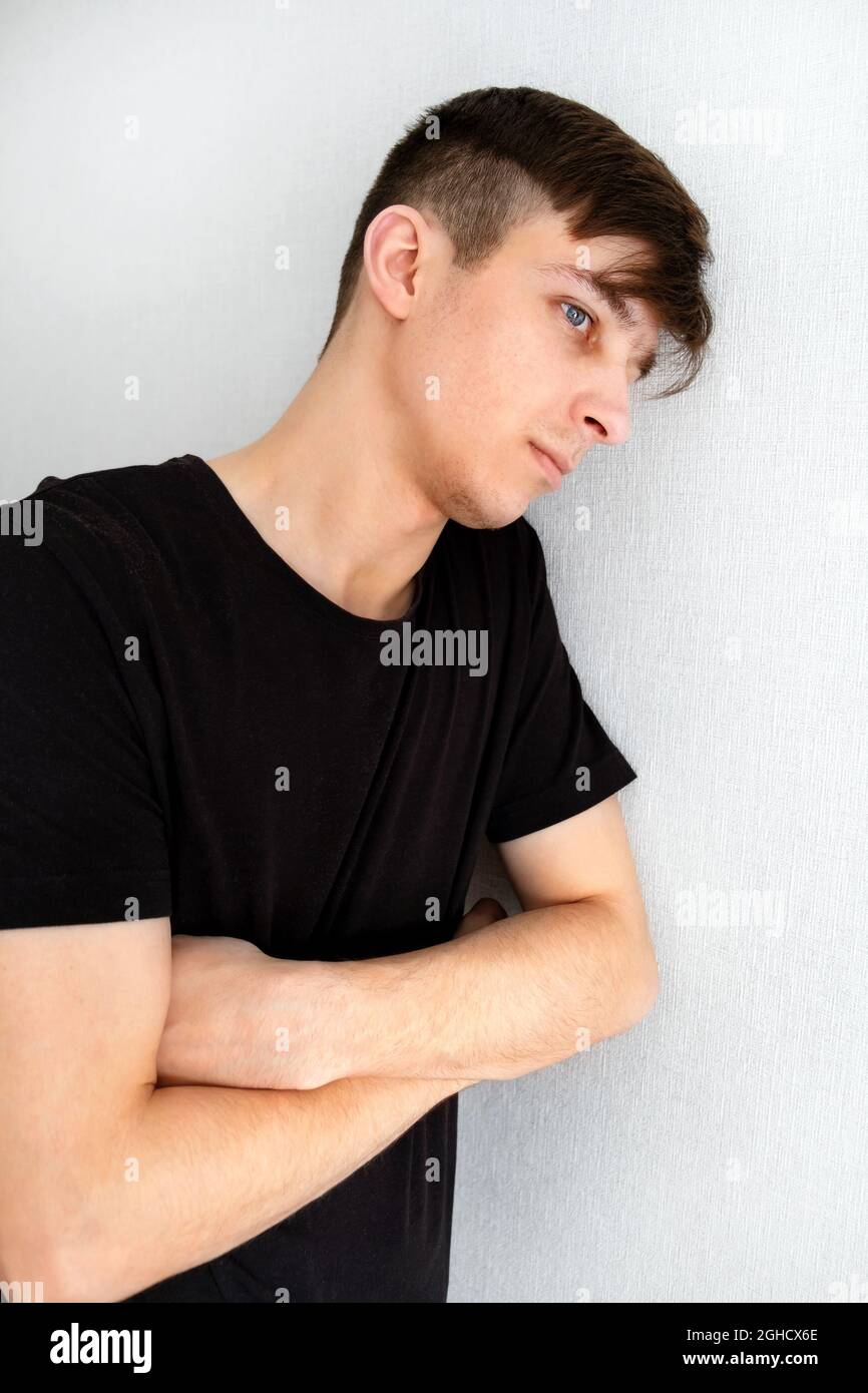 Sad Young Man by the Wall in the Room Stock Photo - Alamy