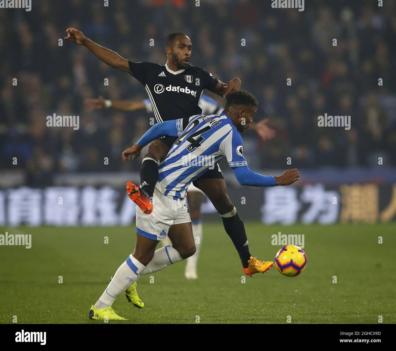 Denis Odoi of Fulham tackles Steve Mounie of Huddersfield Town during ...