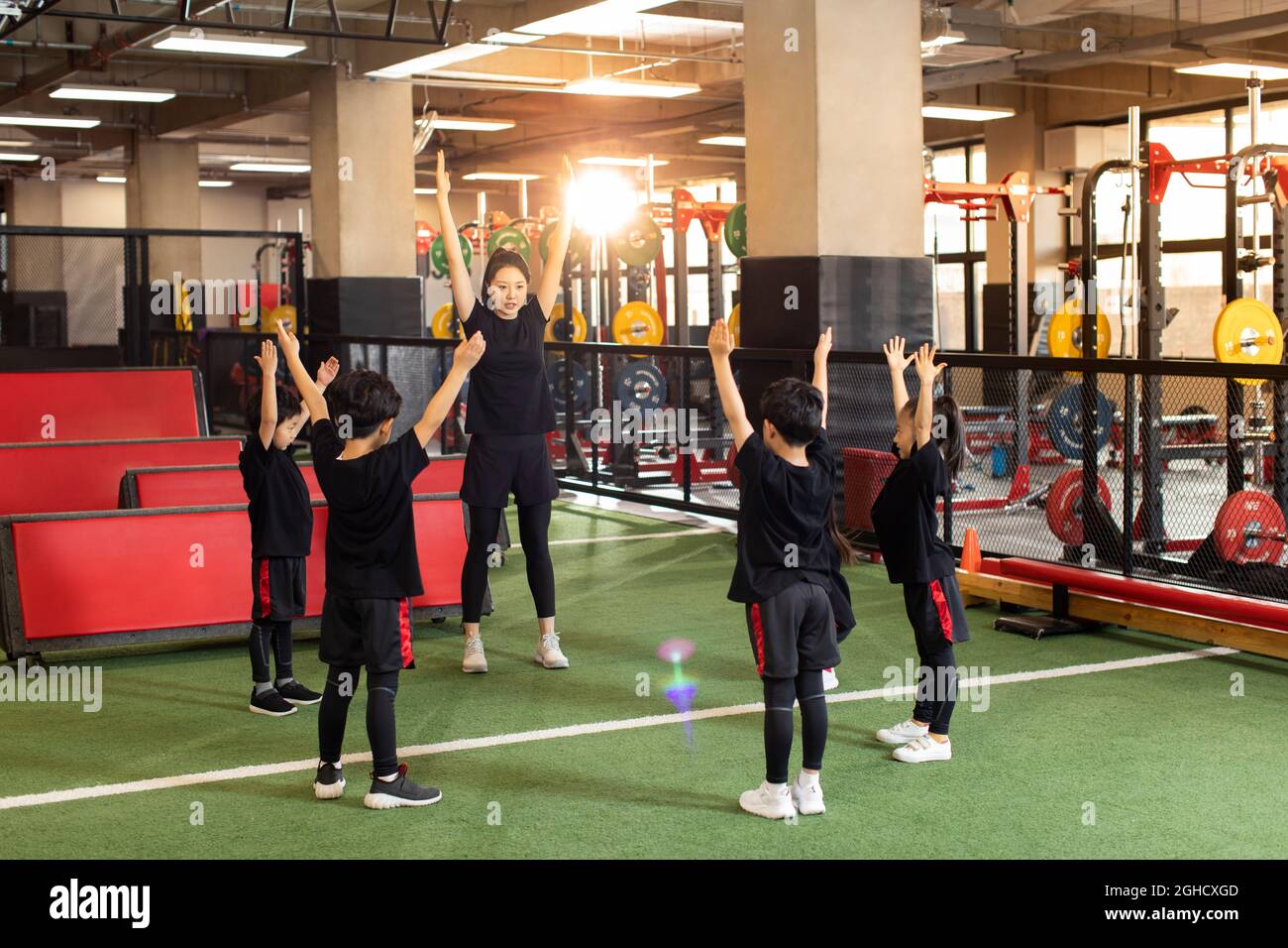 Active children having exercise class with their coach in gym Stock ...