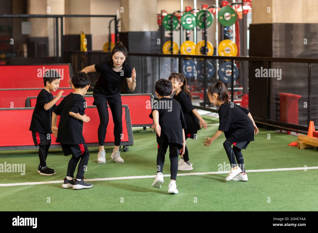 Active children having exercise class with their coach in gym Stock ...