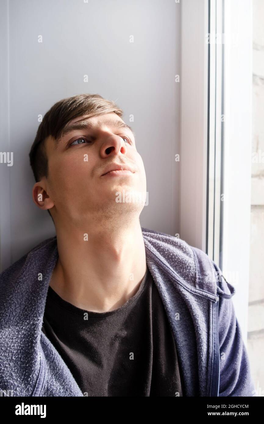 Sad and Pensive Young Man by the Window in the Room Stock Photo - Alamy