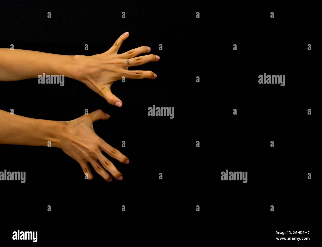 Woman's hands with unusual shapes of fingers against black background ...