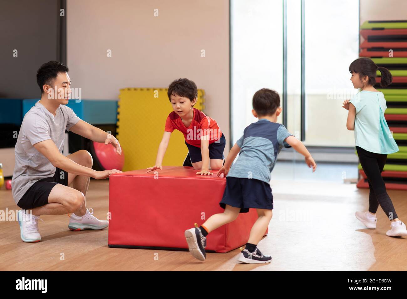Cute children having exercise class in gym Stock Photo - Alamy
