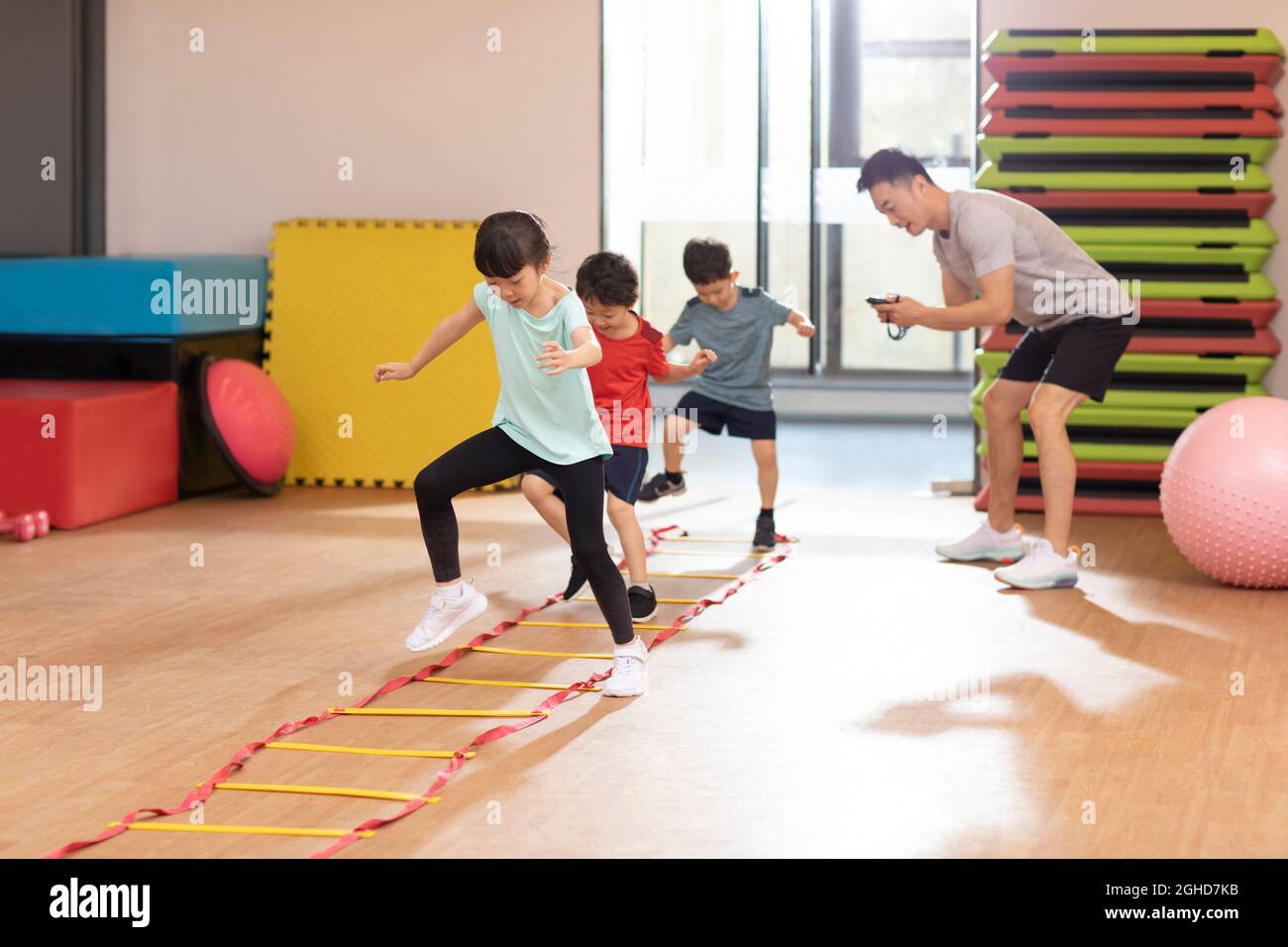 Cute children having exercise class in gym Stock Photo - Alamy