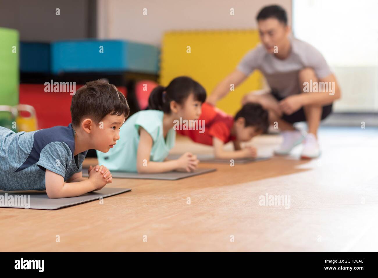 Cute children having exercise class in gym Stock Photo - Alamy