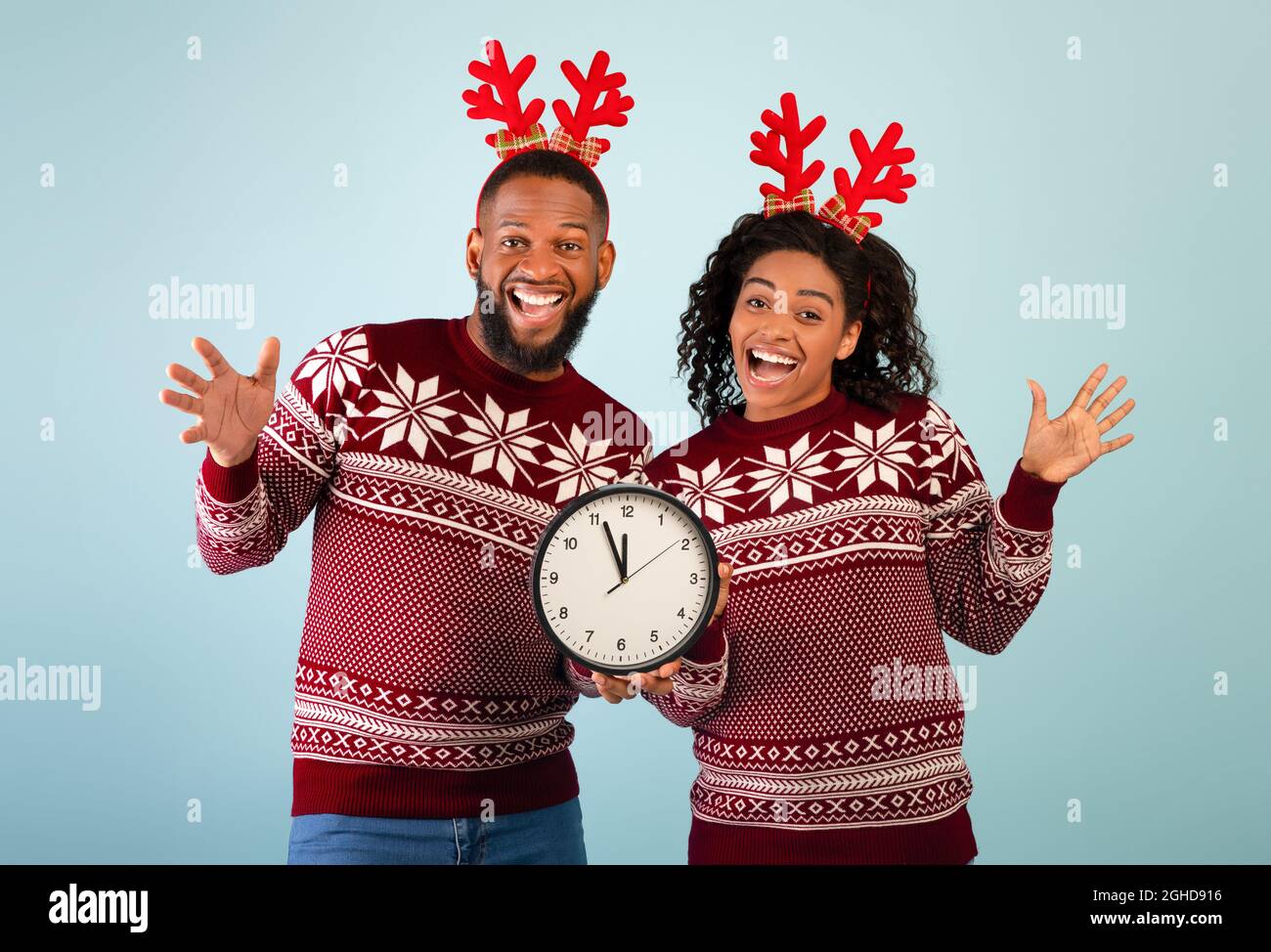 Five minutes to New Year. Overjoyed black couple with clock showing ...