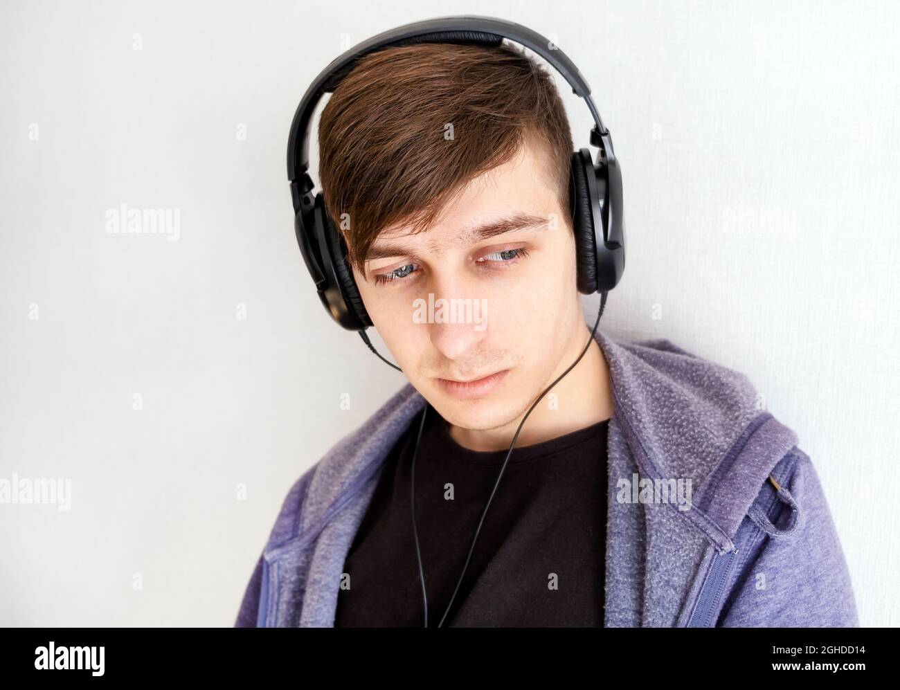 Sad Young Man in Headphones by the White Wall in the Room Stock Photo ...