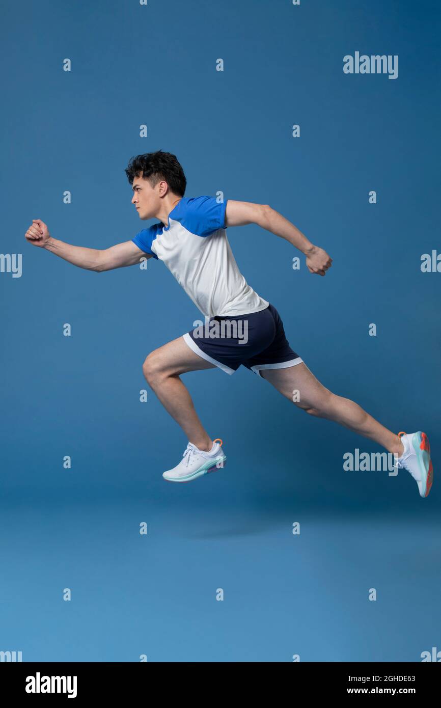 Studio shot of young man running Stock Photo - Alamy