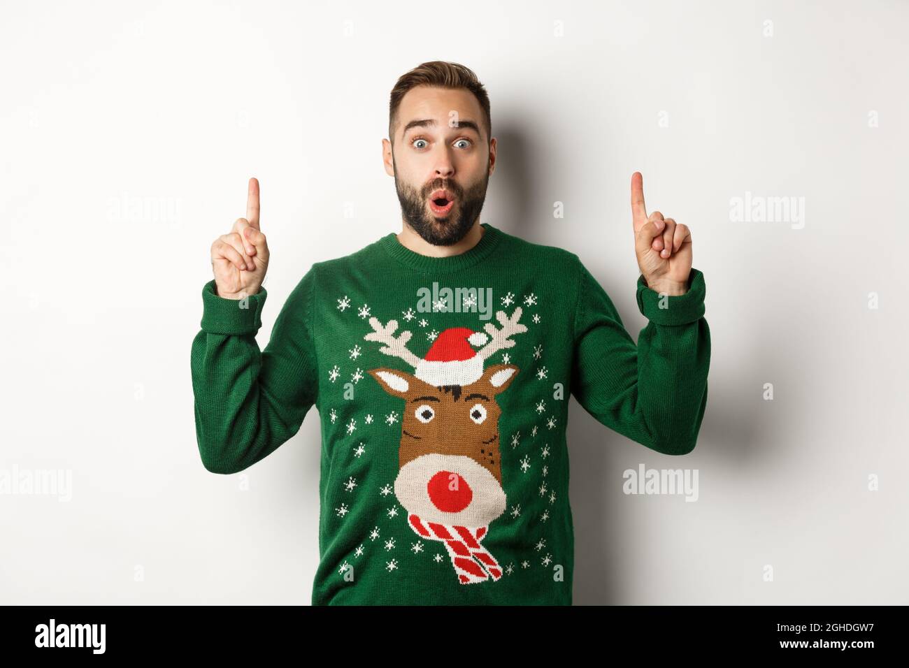 Winter holidays and christmas. Surprised man pointing fingers up ...