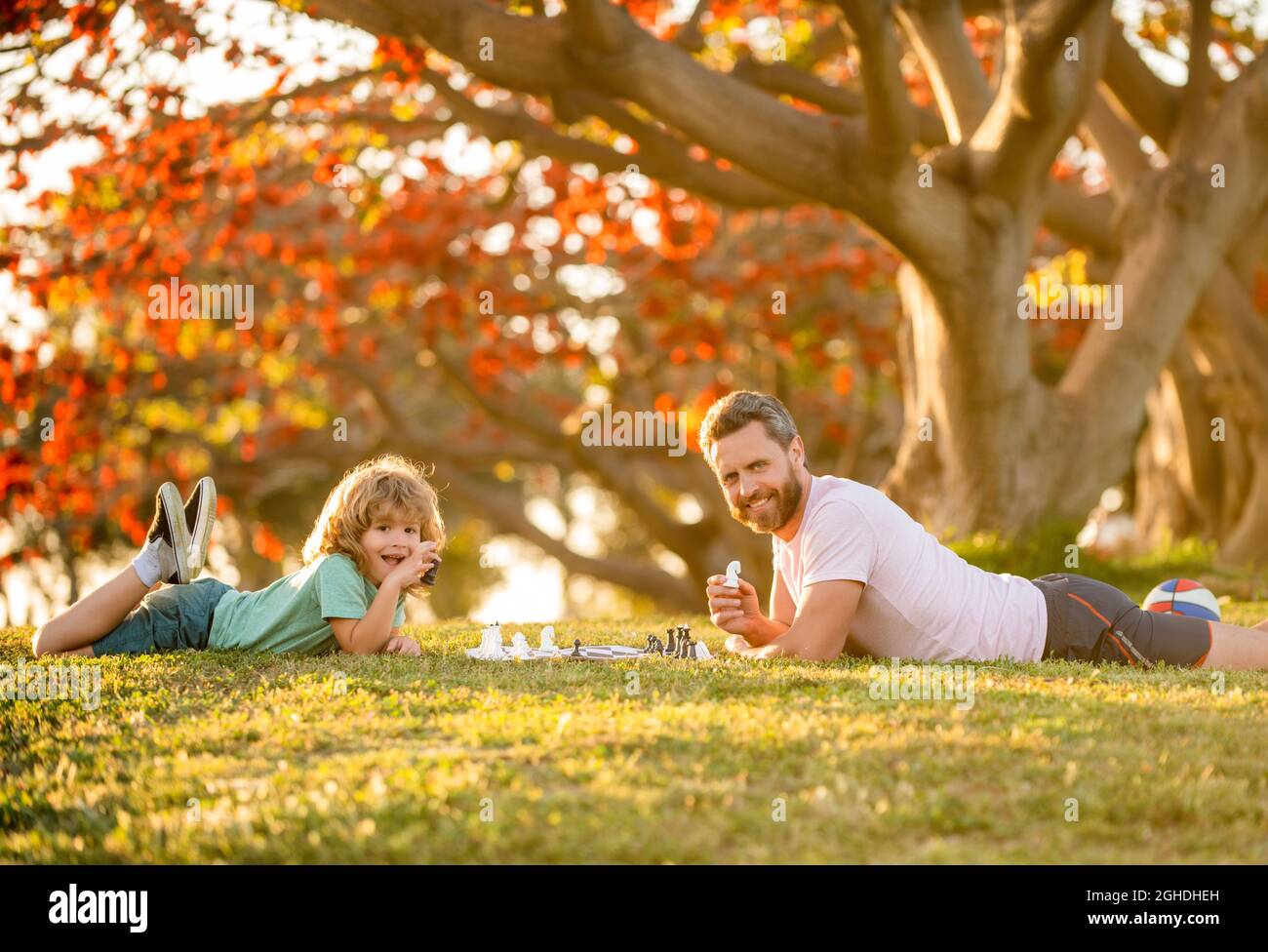 dad and kid play logic game. father and son playing chess in sunset ...