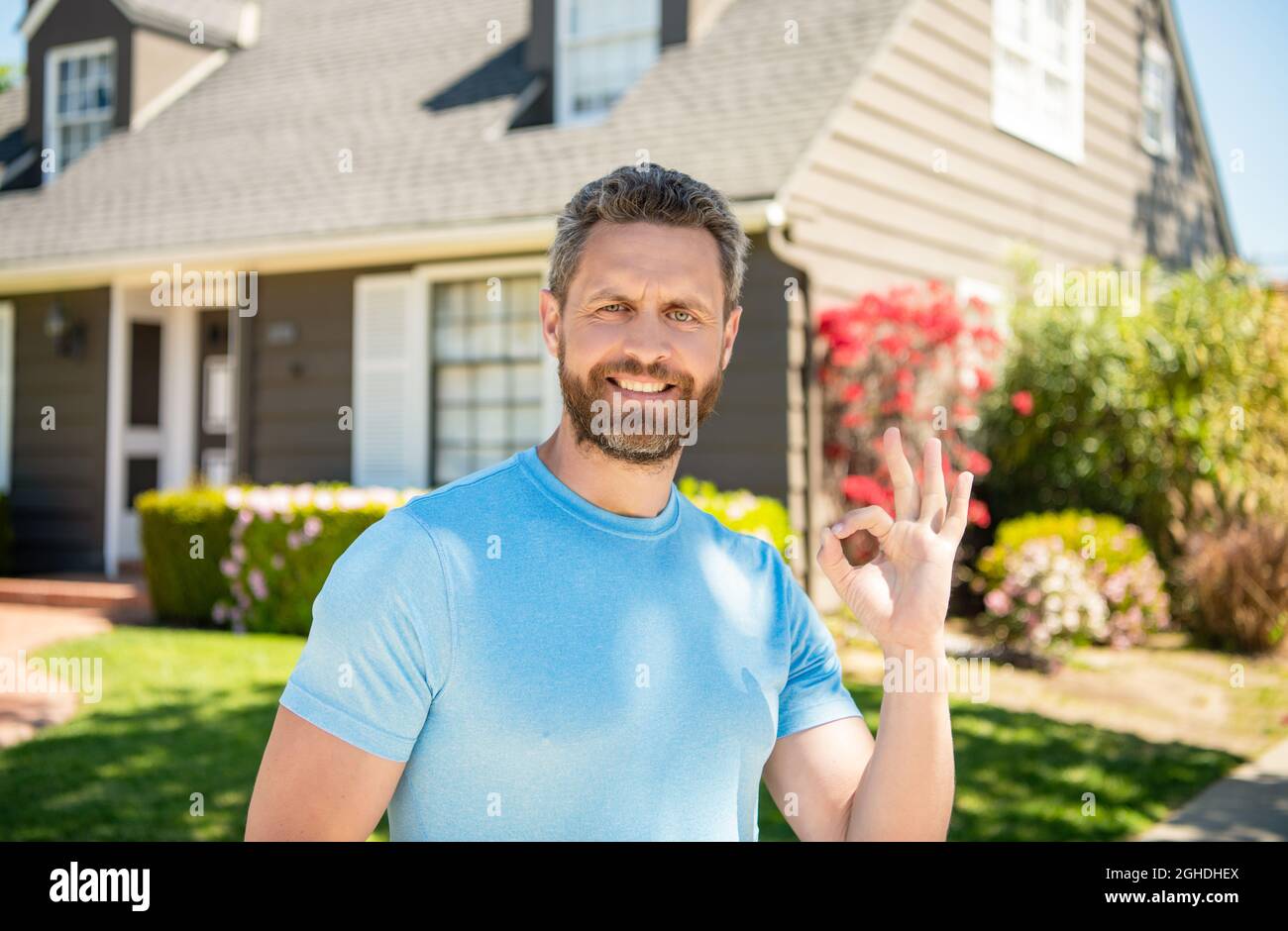 happy mature man standing outdoor at house showing ok, happiness Stock ...