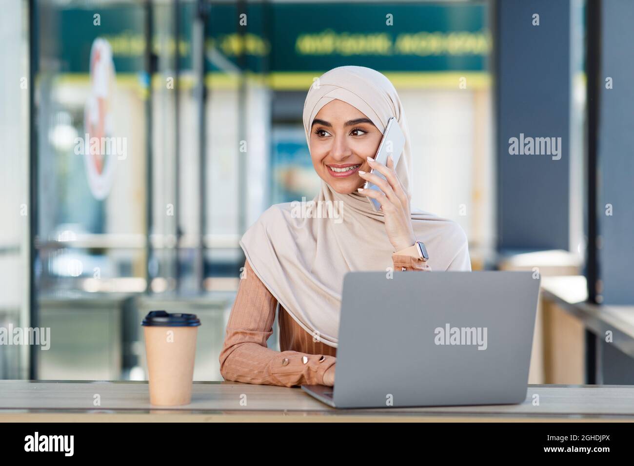 Smiling friendly cute millennial arab muslim woman in hijab speaks on ...