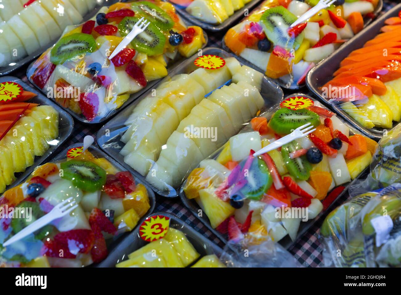 Freshly cutted assorted fruits in sets ready to eat on store showcase ...