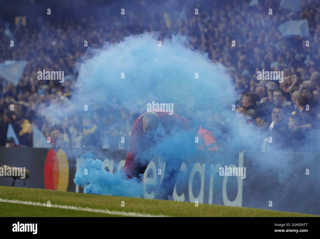 A steward removes a blue flare during the UEFA Champions League match ...