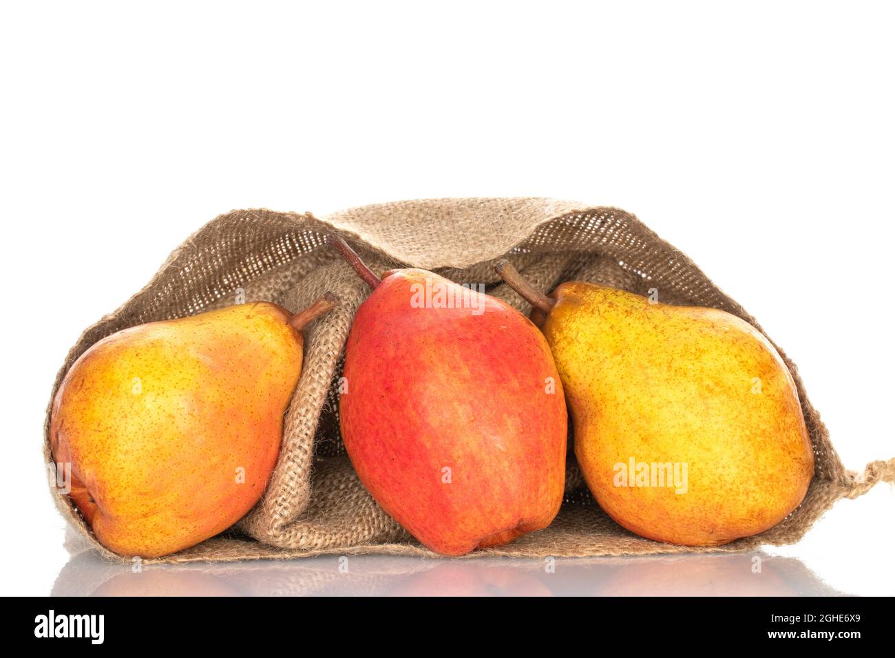 Several juicy red pears with a jute bag, close-up, isolated on white ...