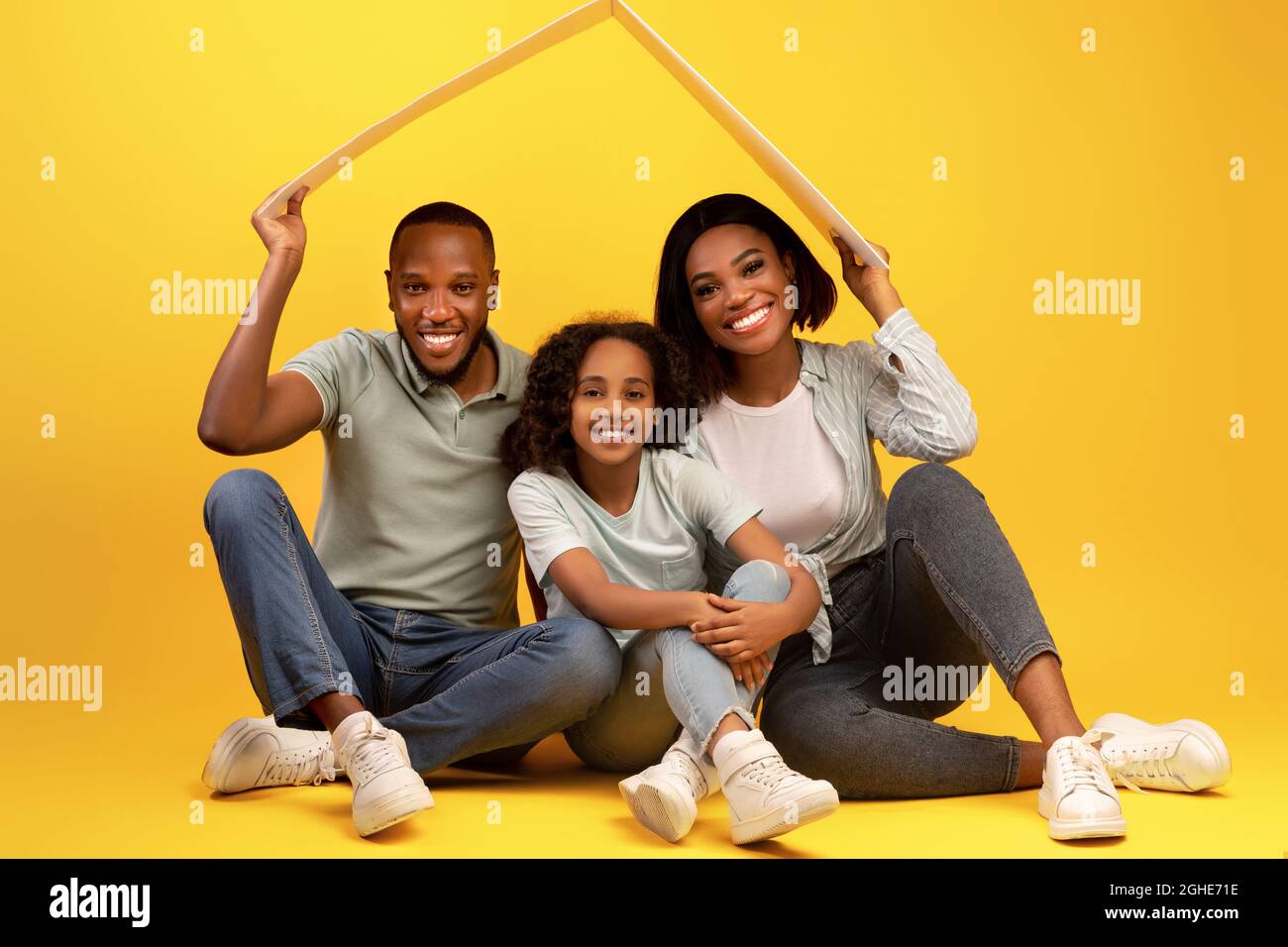Family housing concept. Young black parents and daughter sitting under ...