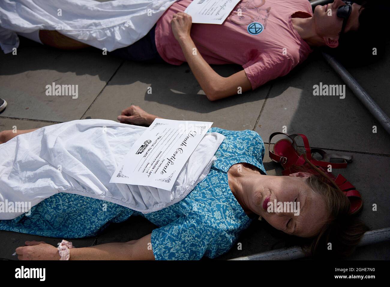 Activists participate in a "Die-In" while laying down on the sidewalk ...