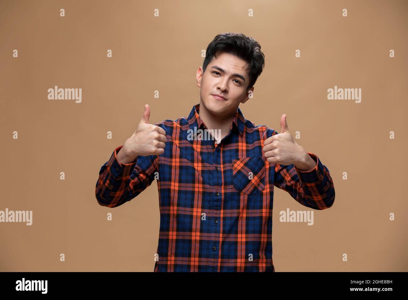 Young man doing thumbs up Stock Photo - Alamy
