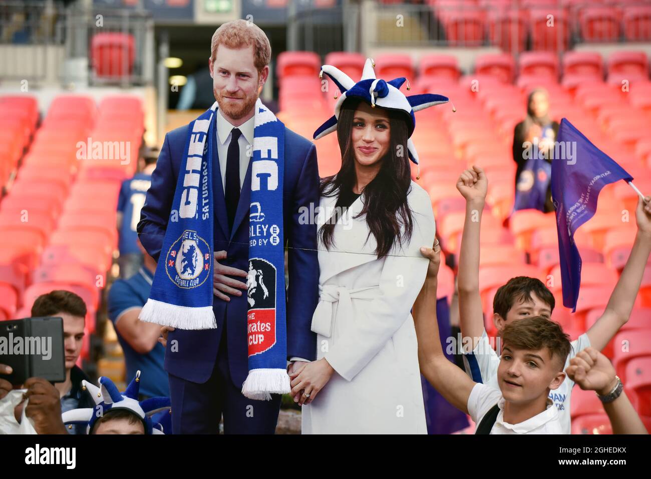 Chelsea fans hold aloft a cardboard Prince Harry and Meghan Markle ...