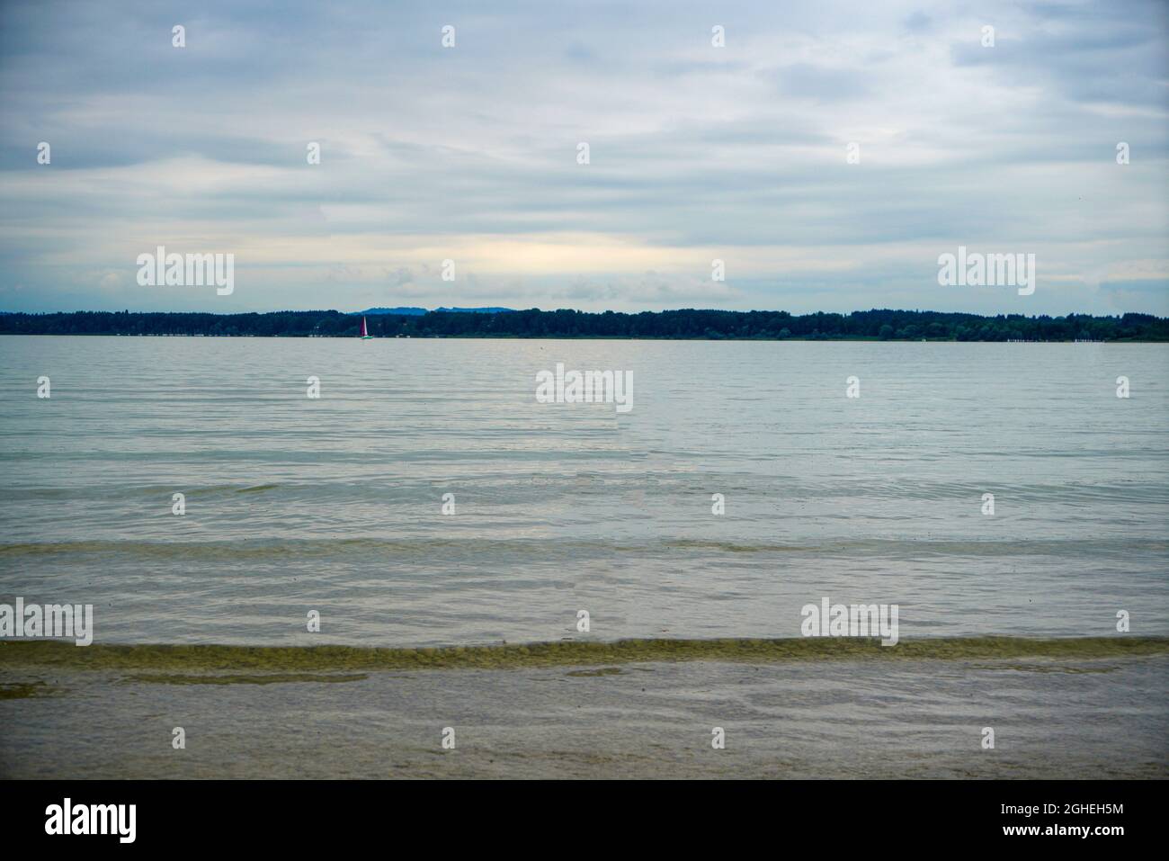 Symmetric landscape from a shore with calm water and hills on the ...