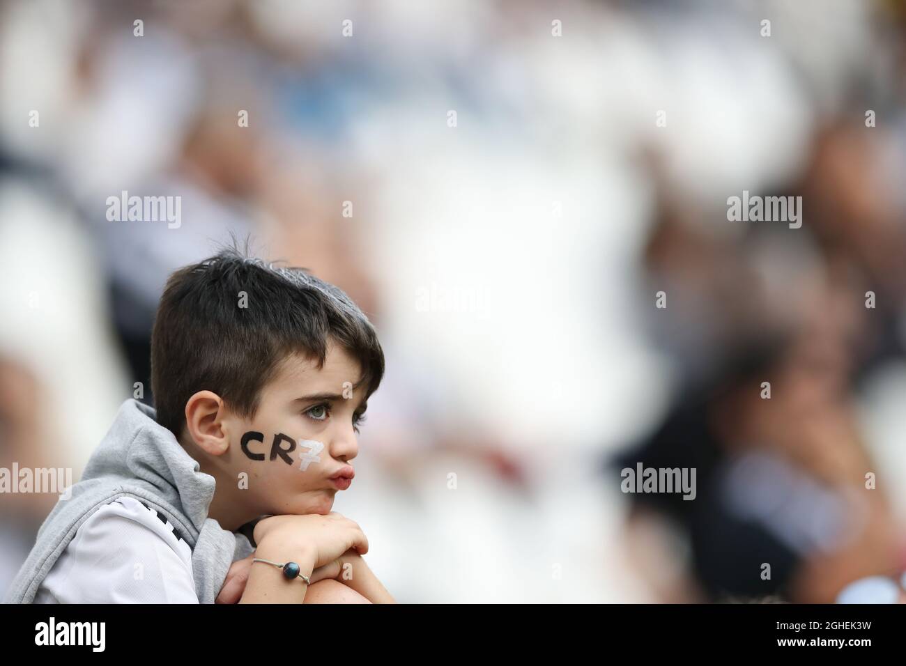 A young fan with Cristiano Ronaldo's initials and number painted on his ...