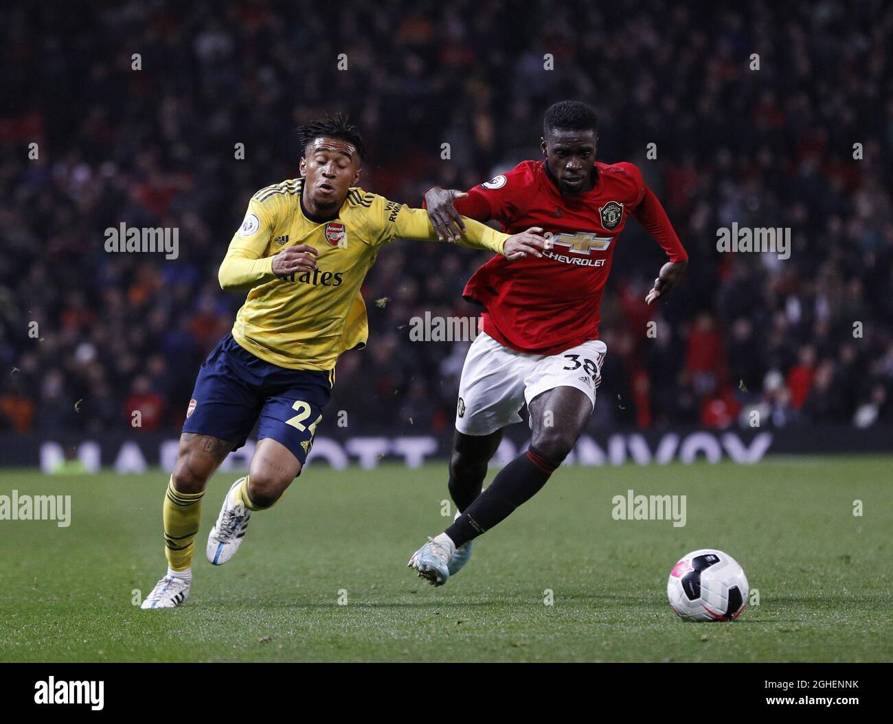 Reiss Nelson of Arsenal tussles with Axel Tuanzebe of Manchester ...