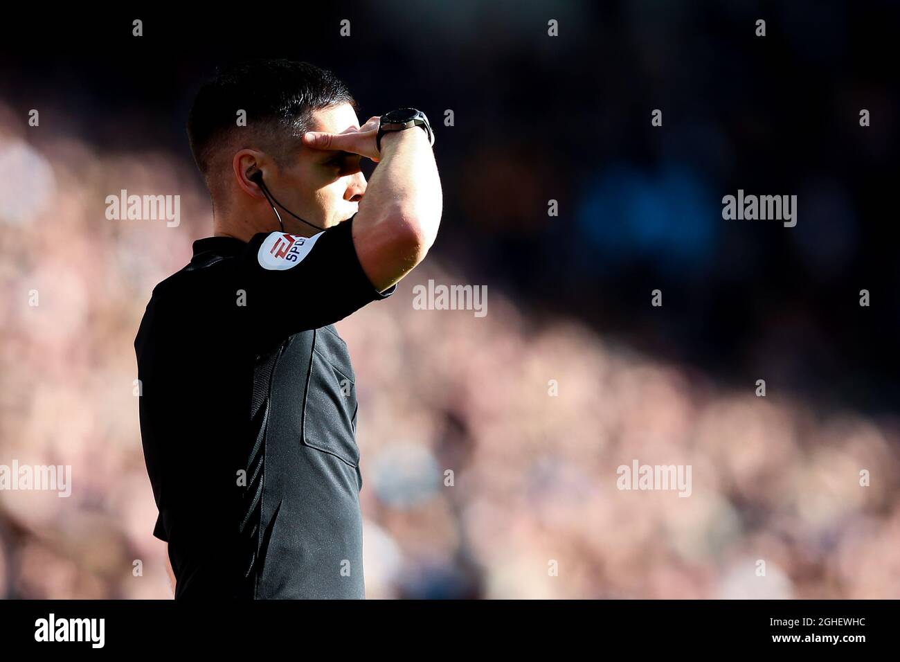 The assistant referee shields his eyes from the sun hi-res stock ...