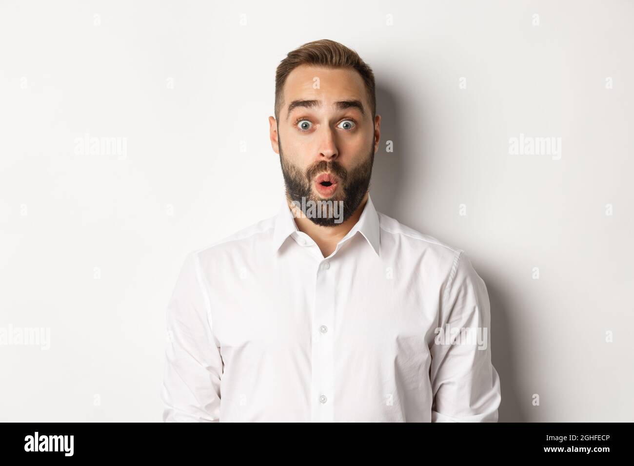 Close-up of impressed man saying wow, looking amazed at camera ...