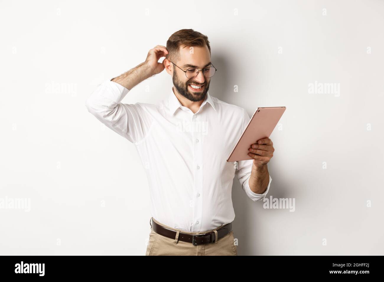Confused male manager looking puzzled at digital tablet, scratching ...