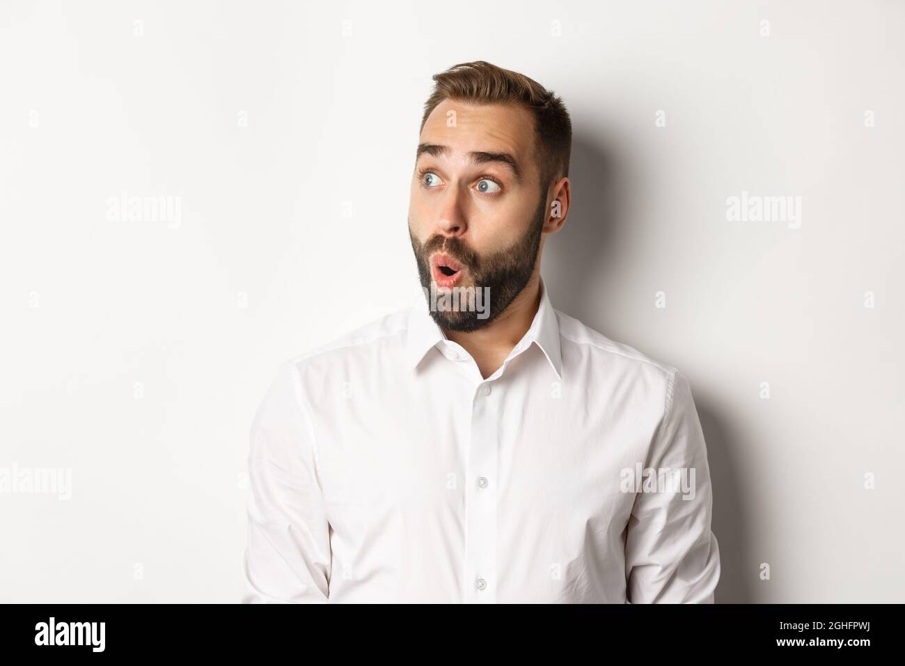 Close-up of happy and surprised man looking left with amazed face ...