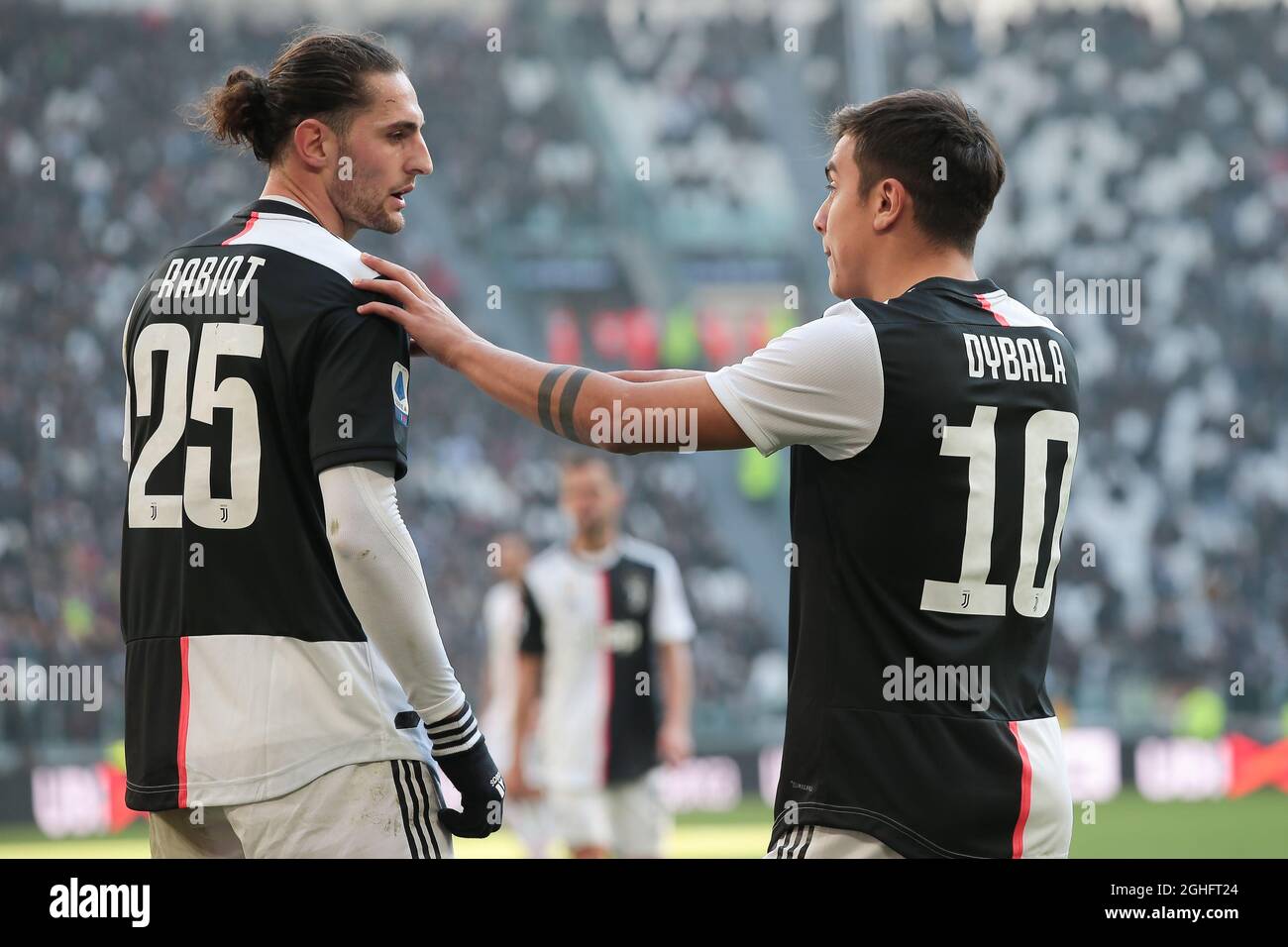 Paulo Dybala of Juventus speaks with team mate Adrien Rabiot during the ...