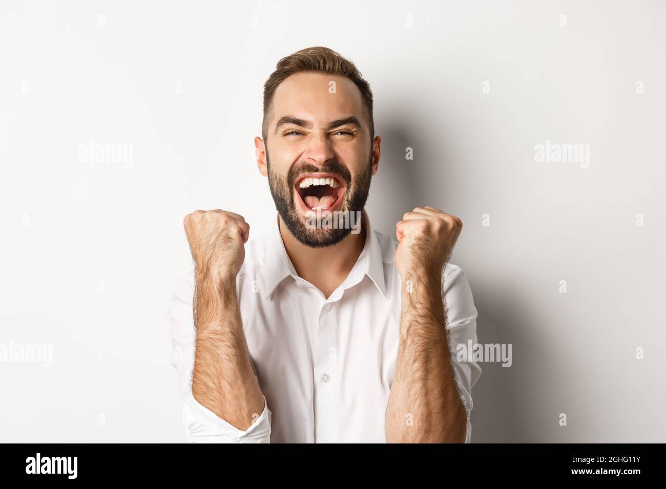 Close-up of successful caucasian man rejoicing of winning, making fist ...