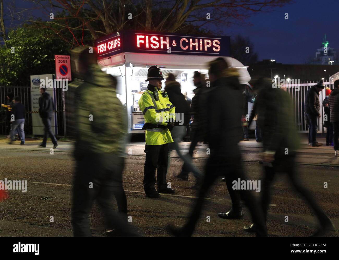 Fans pass a static policemen on the their way to the stadiumduring the ...