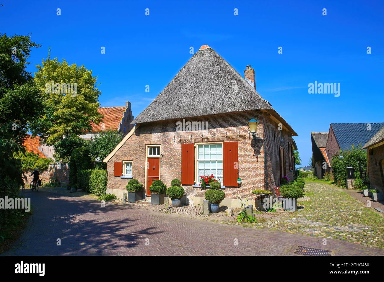 view on typical old dutch stone house with thatched roof against blue ...